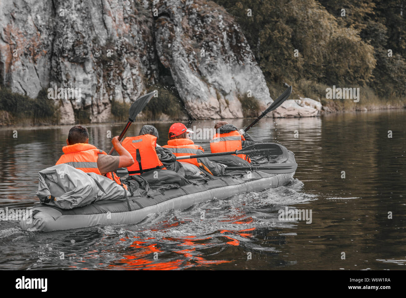 A group of friends in an inflatable raft moving down a river Stock ...