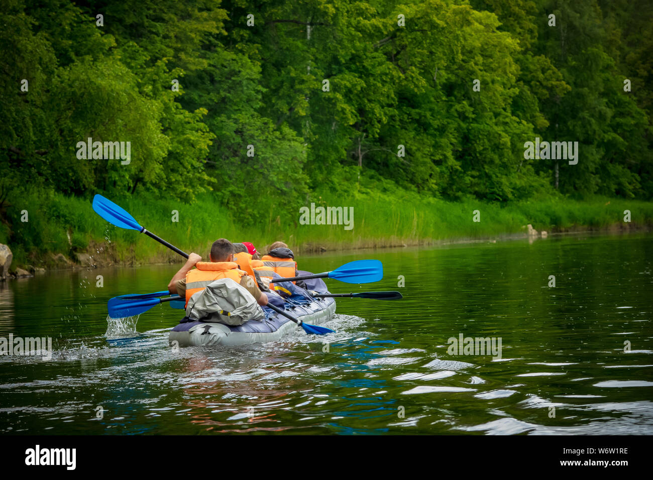 A group of friends in an inflatable raft moving down a river Stock ...