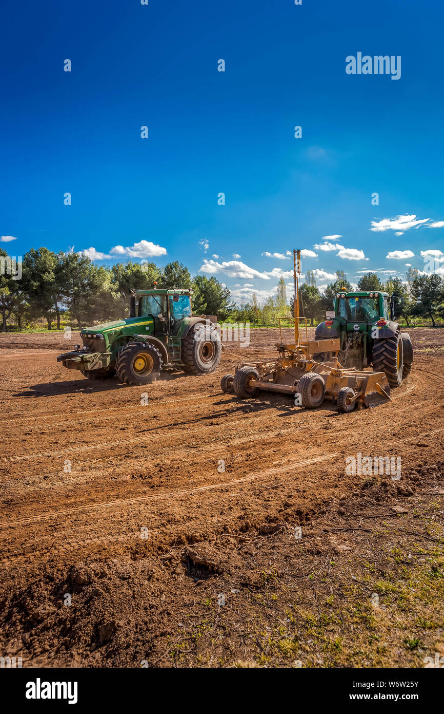 Tractors leveling in the field Stock Photo - Alamy