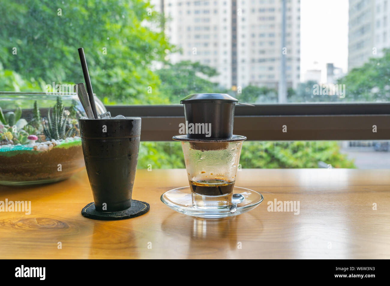 Vietnamese fin coffee next to window with beautiful city view Stock ...