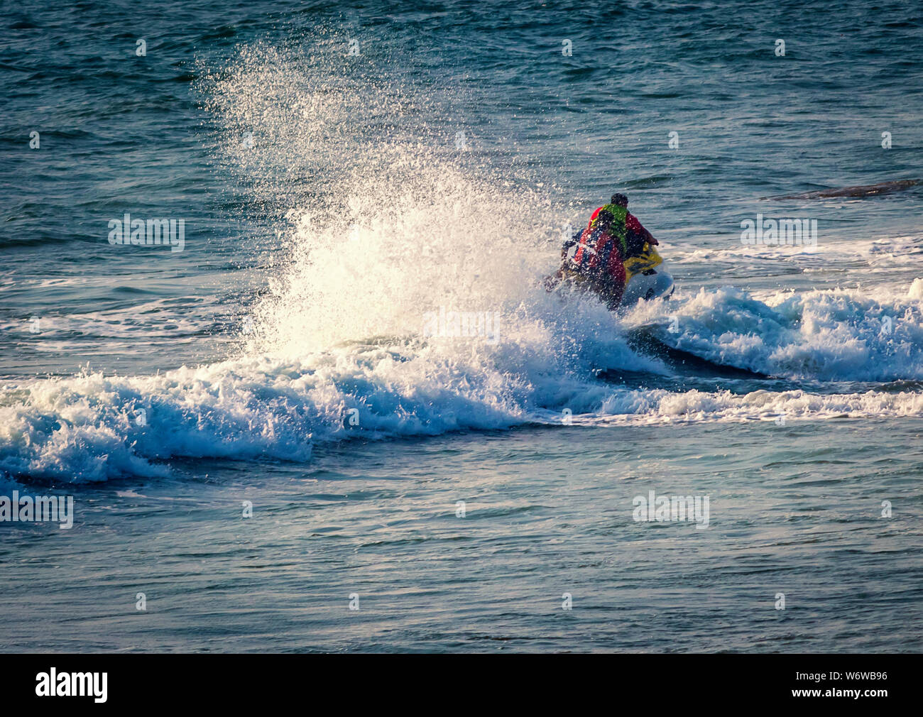 Young couple riding a jet ski / wave runner in Goa sea, wearing safety ...