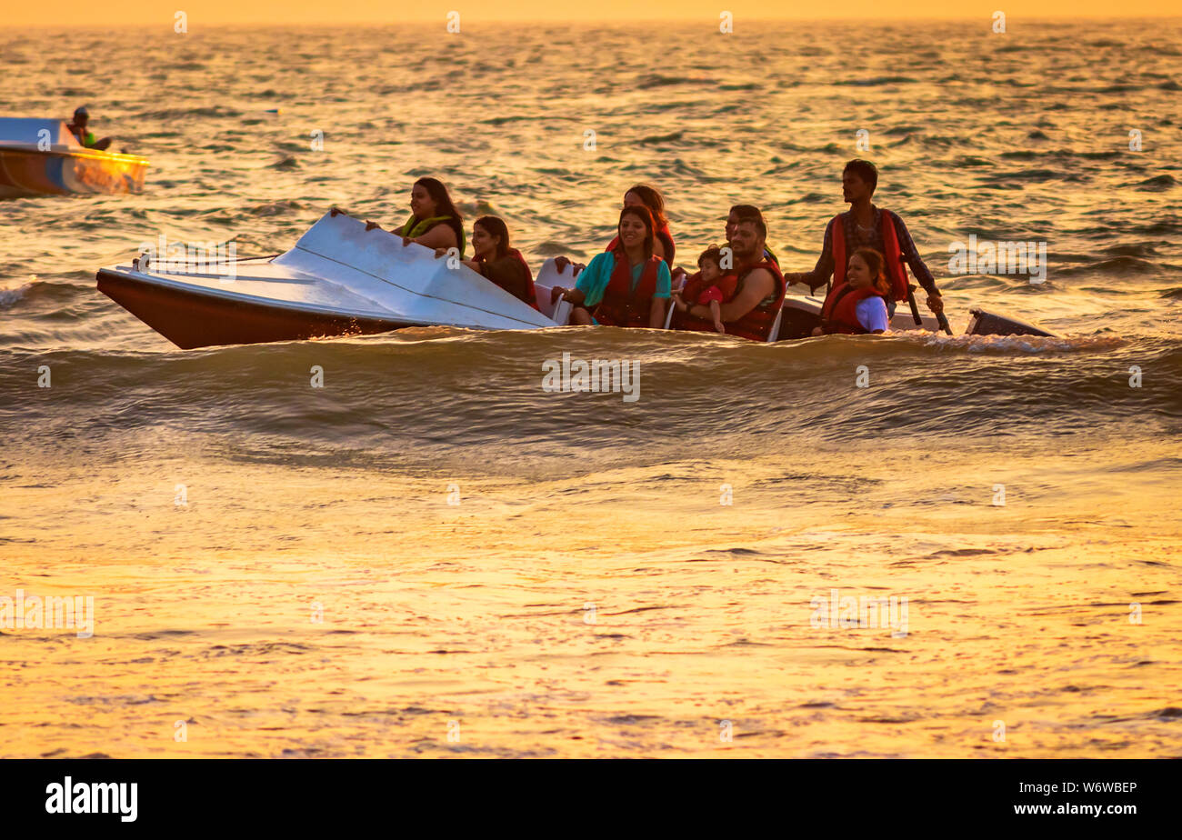 Young couple riding a jet ski / wave runner in Goa sea, wearing safety ...