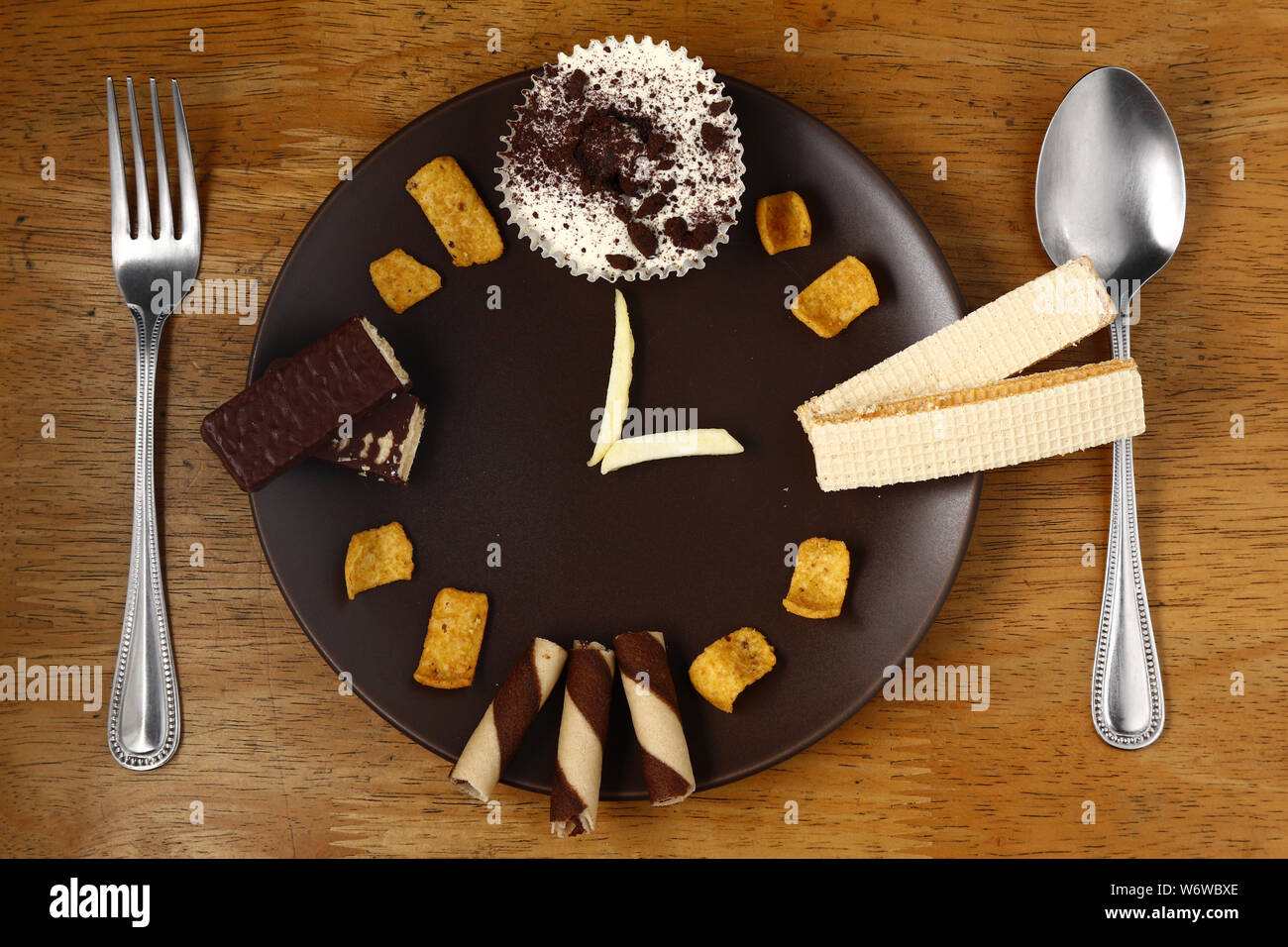 Photo of different unhealthy snacks or junk food arranged like a clock ...