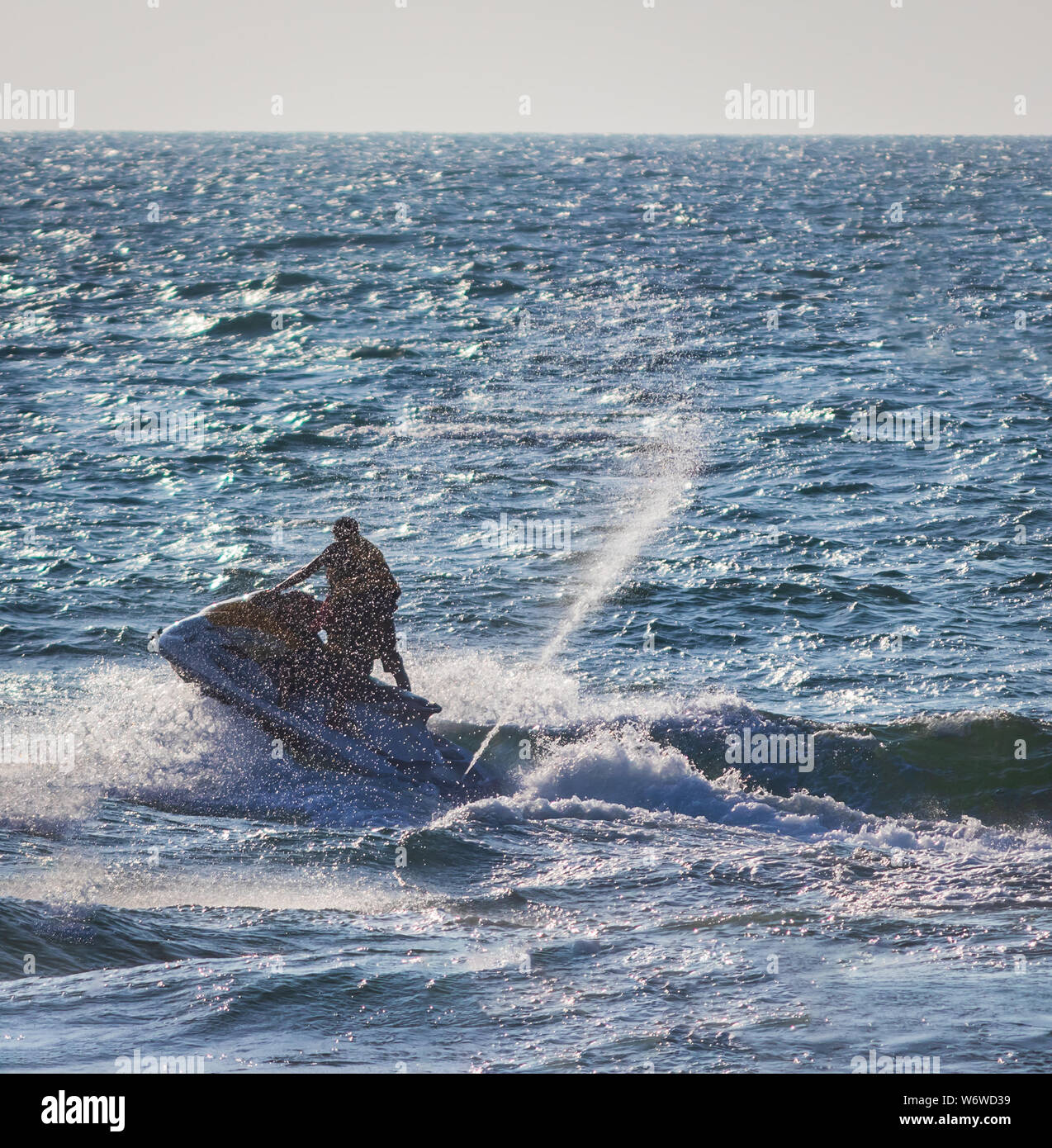 Young couple riding a jet ski / wave runner in Goa sea, wearing safety ...