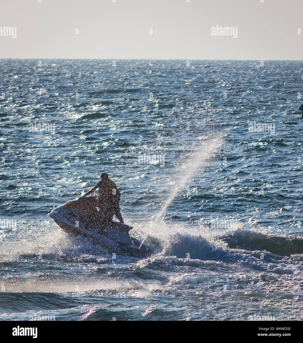 Young couple riding a jet ski / wave runner in Goa sea, wearing safety ...