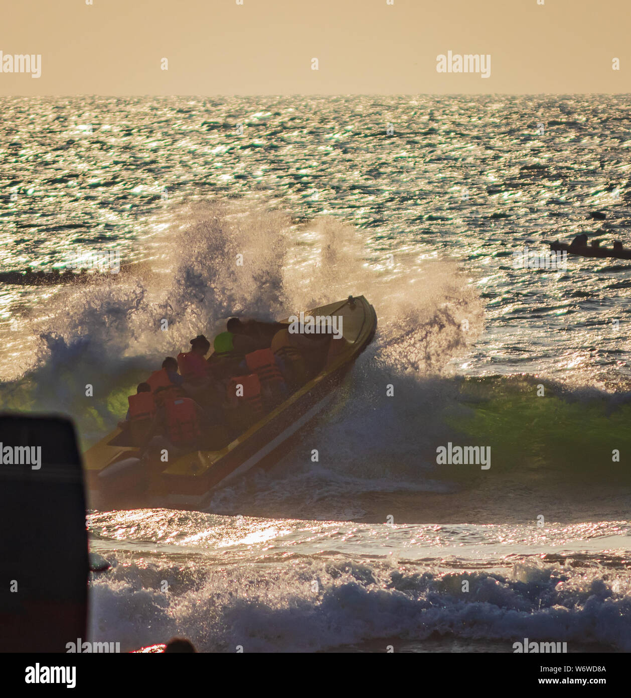 Young couple riding a jet ski / wave runner in Goa sea, wearing safety ...