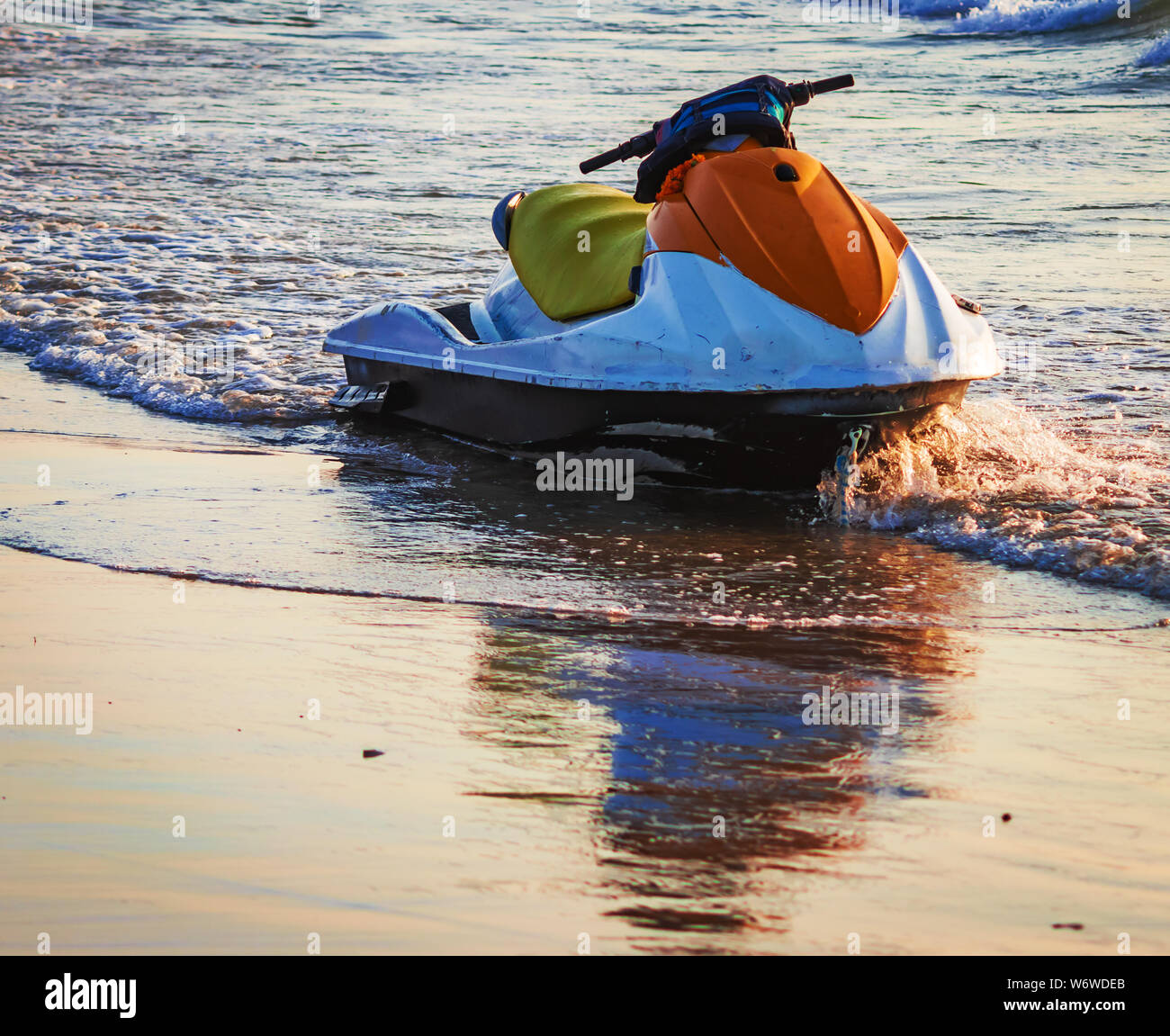 Young couple riding a jet ski / wave runner in Goa sea, wearing safety ...