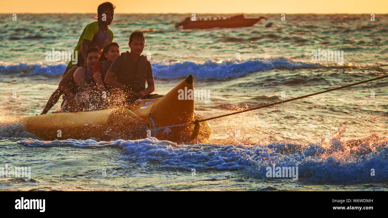 Young couple riding a jet ski / wave runner in Goa sea, wearing safety ...