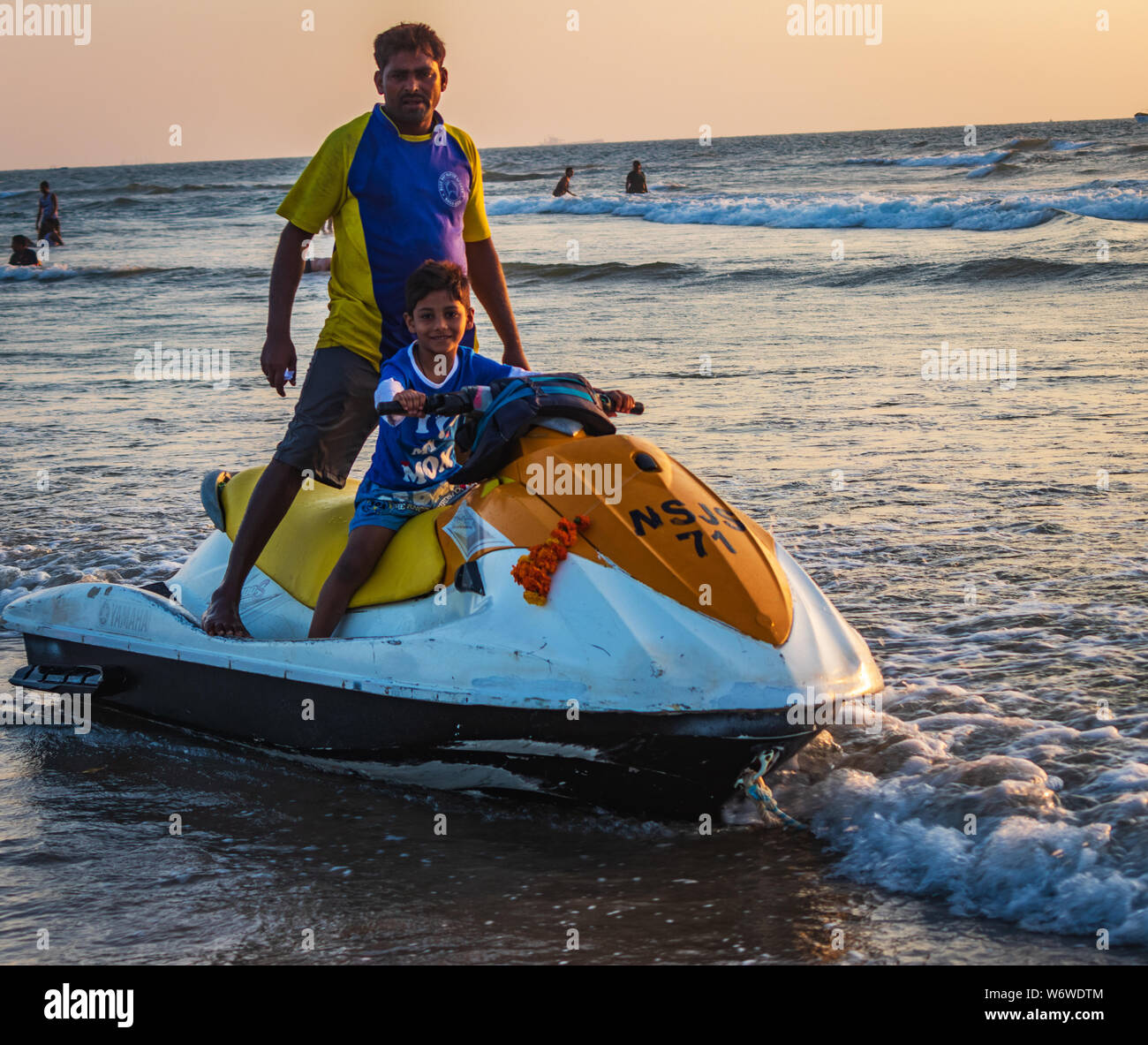 Young couple riding a jet ski / wave runner in Goa sea, wearing safety ...