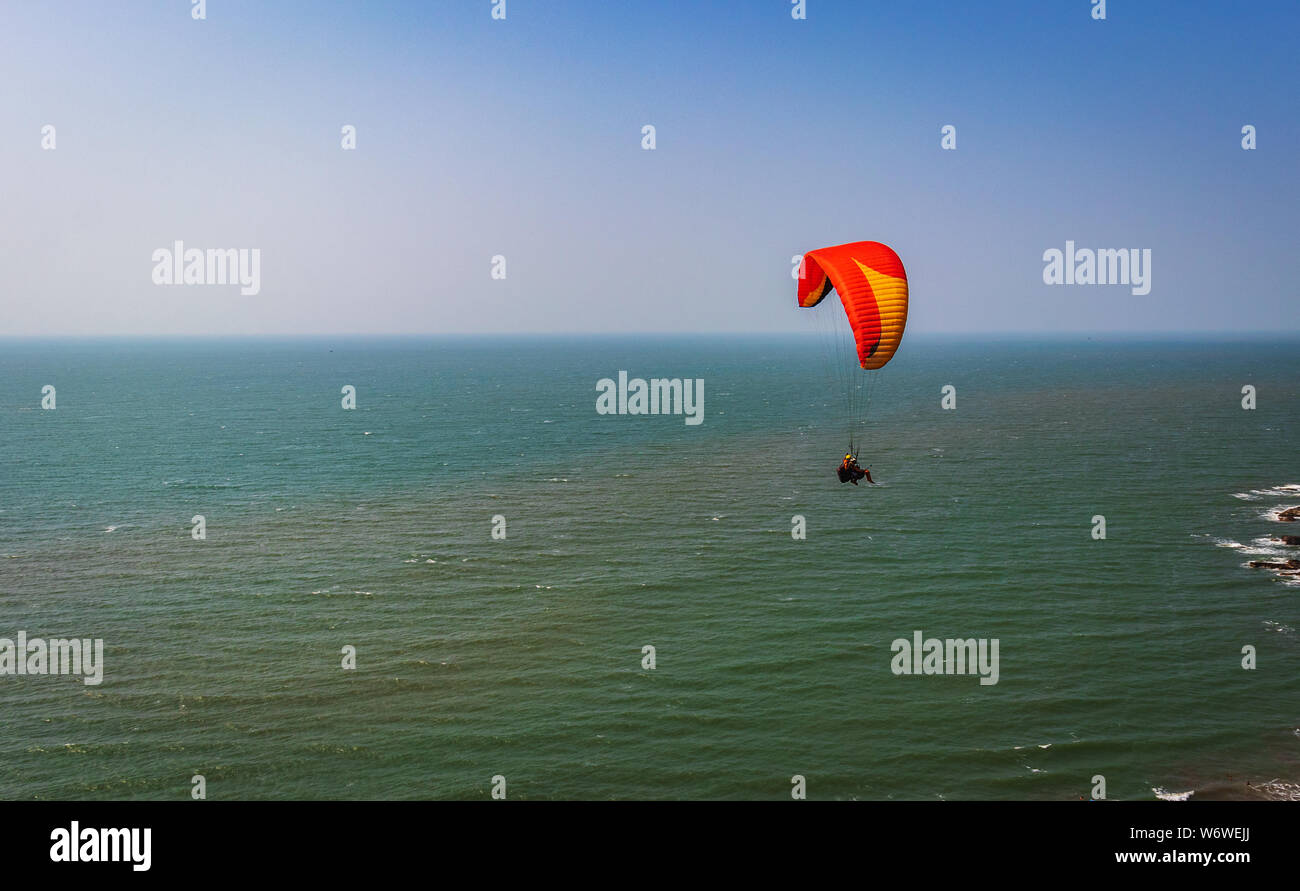 Paragliding in the sky. Paraglider tandem flying over the sea with blue ...