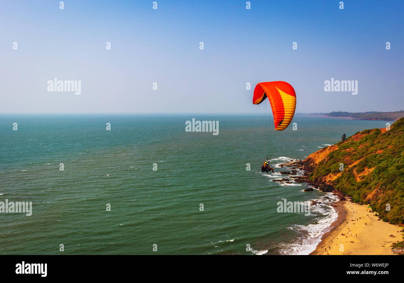 Paragliding in the sky. Paraglider tandem flying over the sea with blue ...