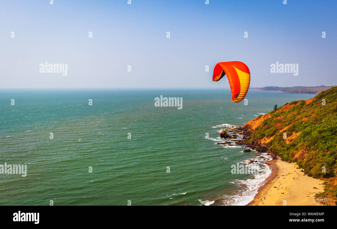 Paragliding in the sky. Paraglider tandem flying over the sea with blue ...