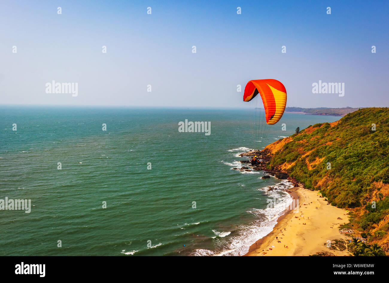 Paragliding in the sky. Paraglider tandem flying over the sea with blue ...