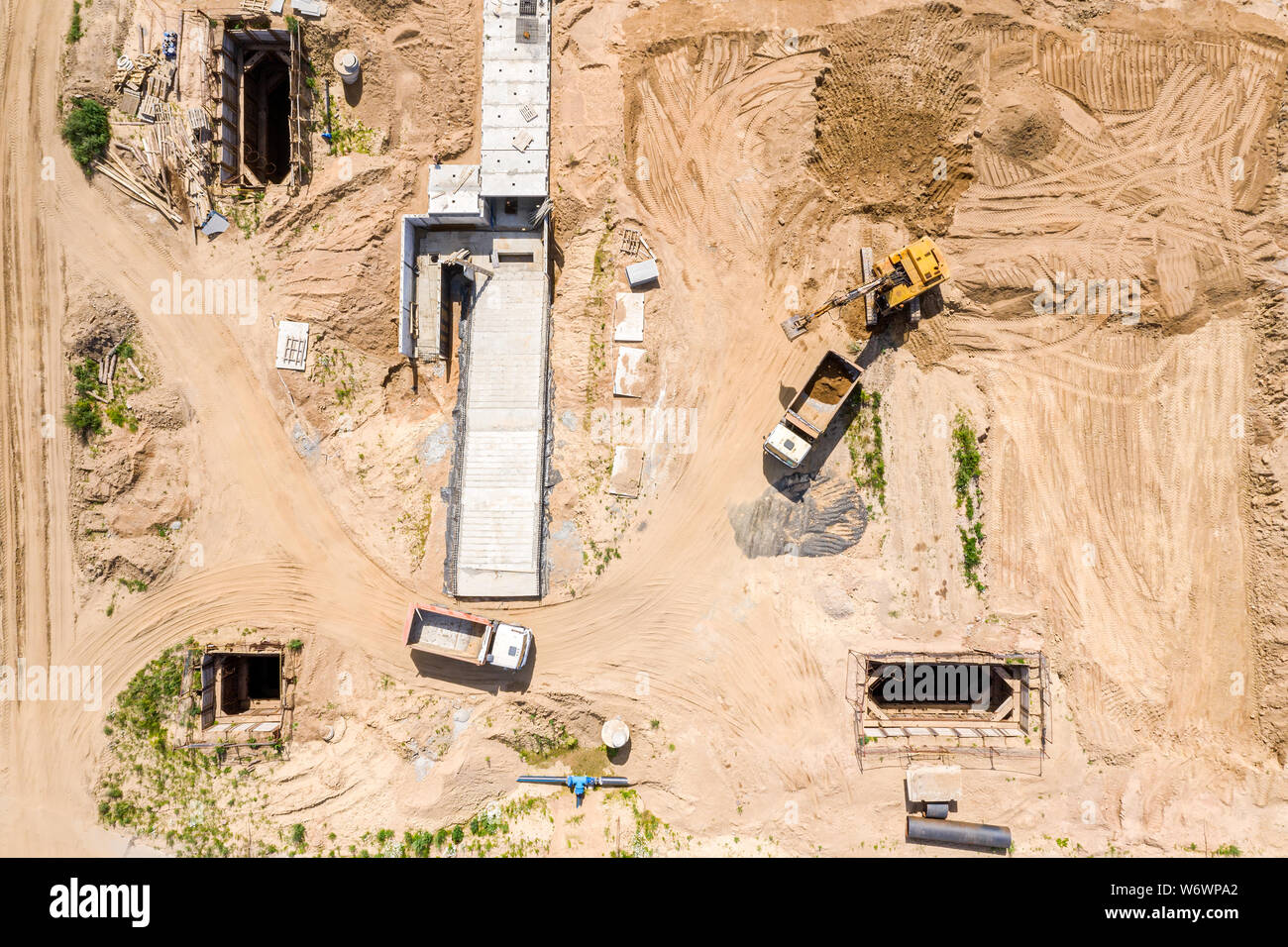 aerial top view of industrial excavators and dump trucks preparing ...