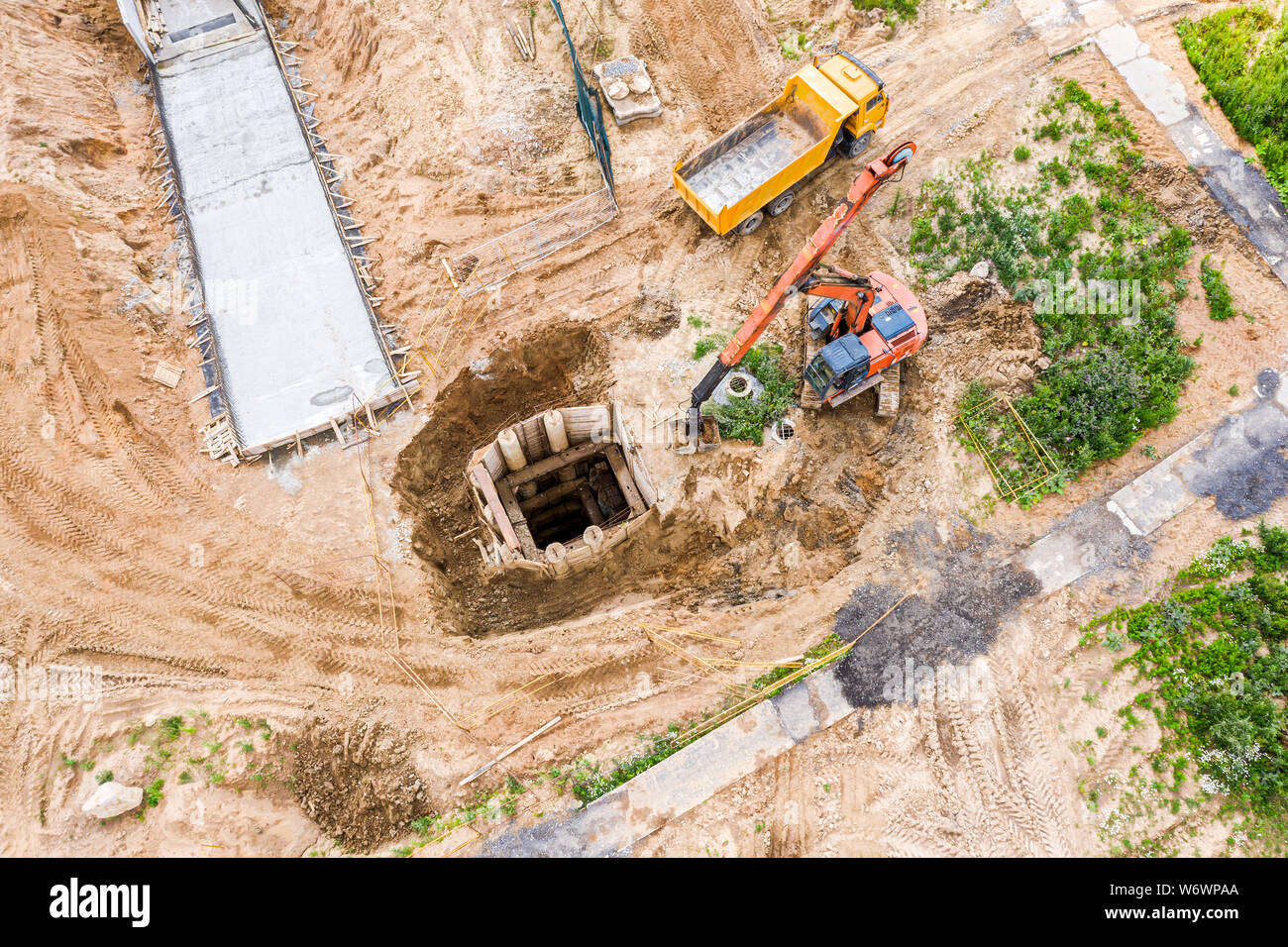 industrial excavator and dump truck working at construction site, top ...