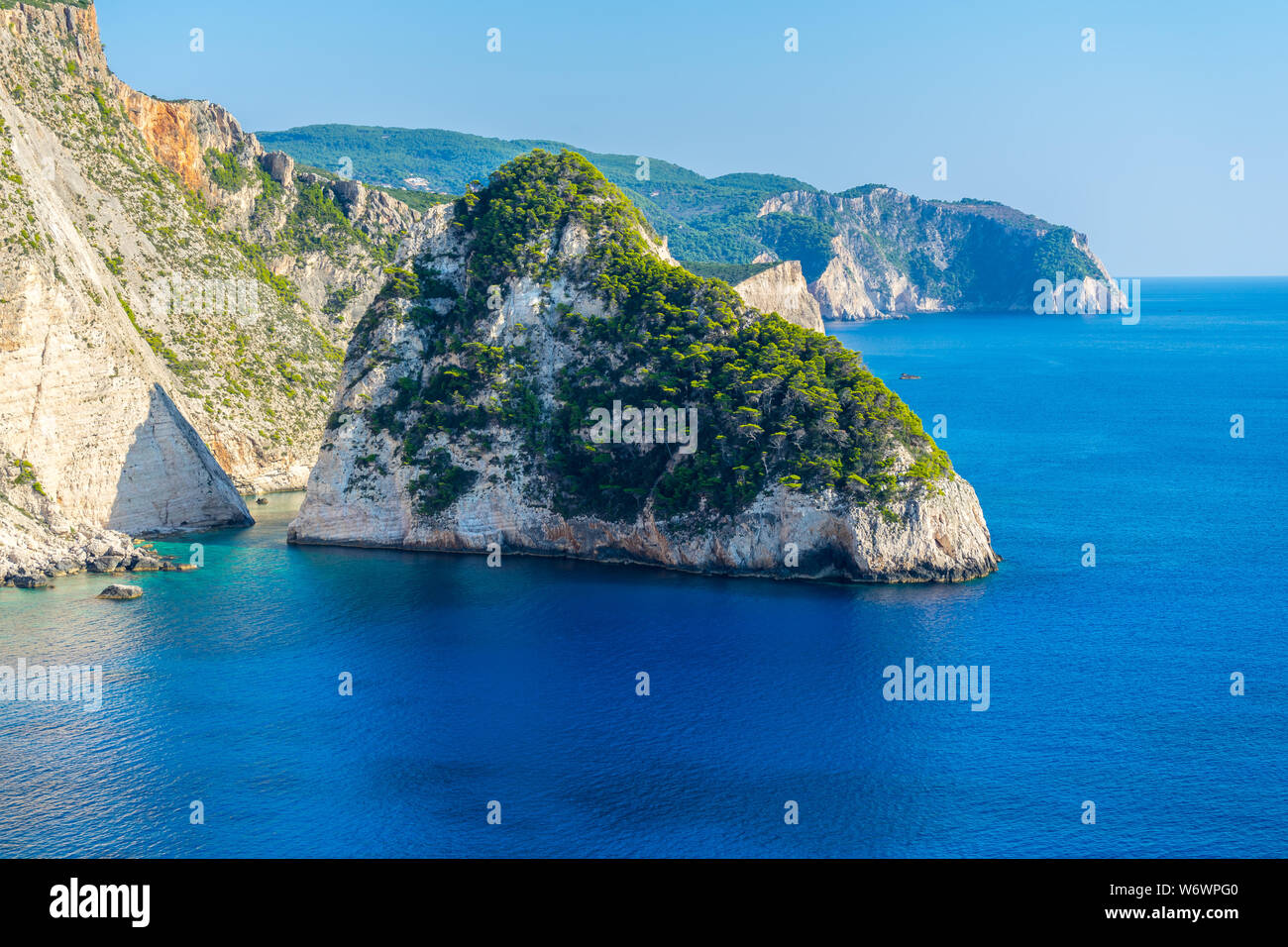 Greece, Zakynthos, Green tree covered plakaki isle in azure waters ...