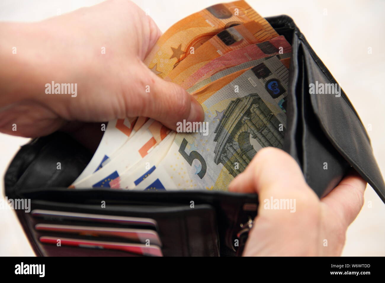 Person holding wallet with euros hi-res stock photography and images ...