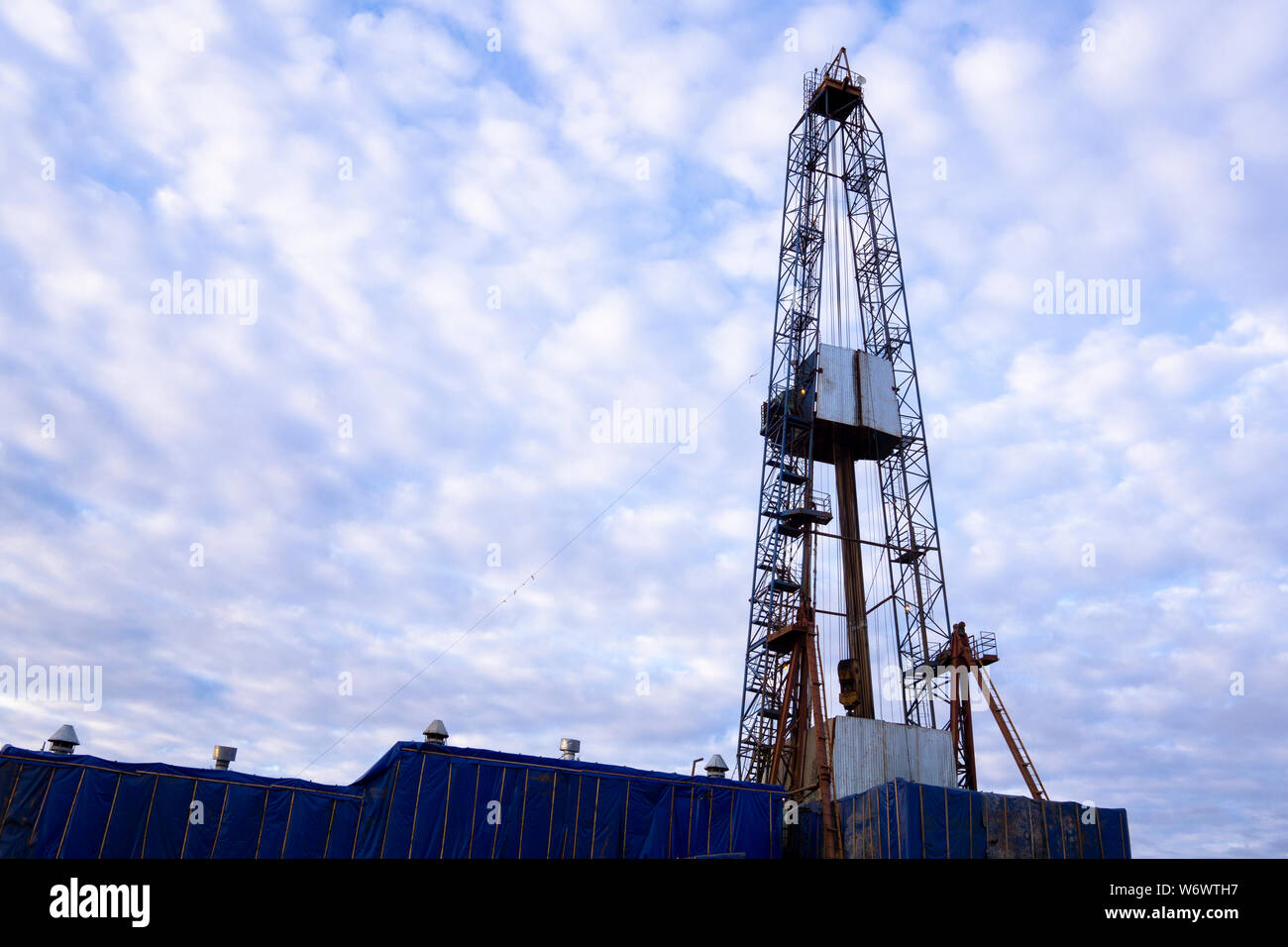 Oil and Gas Drilling Rig onshore dessert with dramatic cloudscape. Oil drilling rig operation on ...