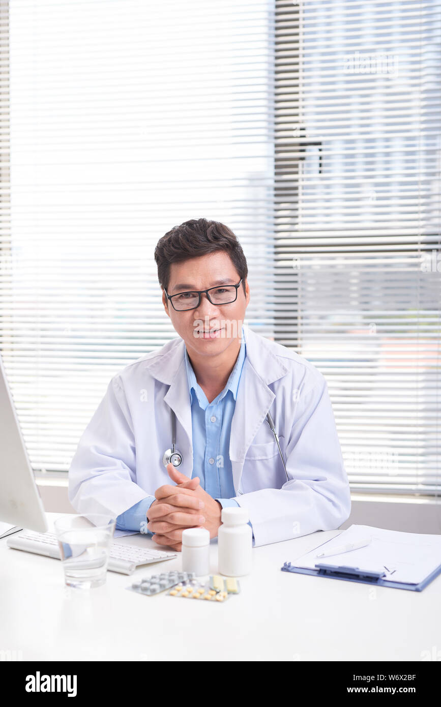 Doctor sitting at desk hi-res stock photography and images - Alamy