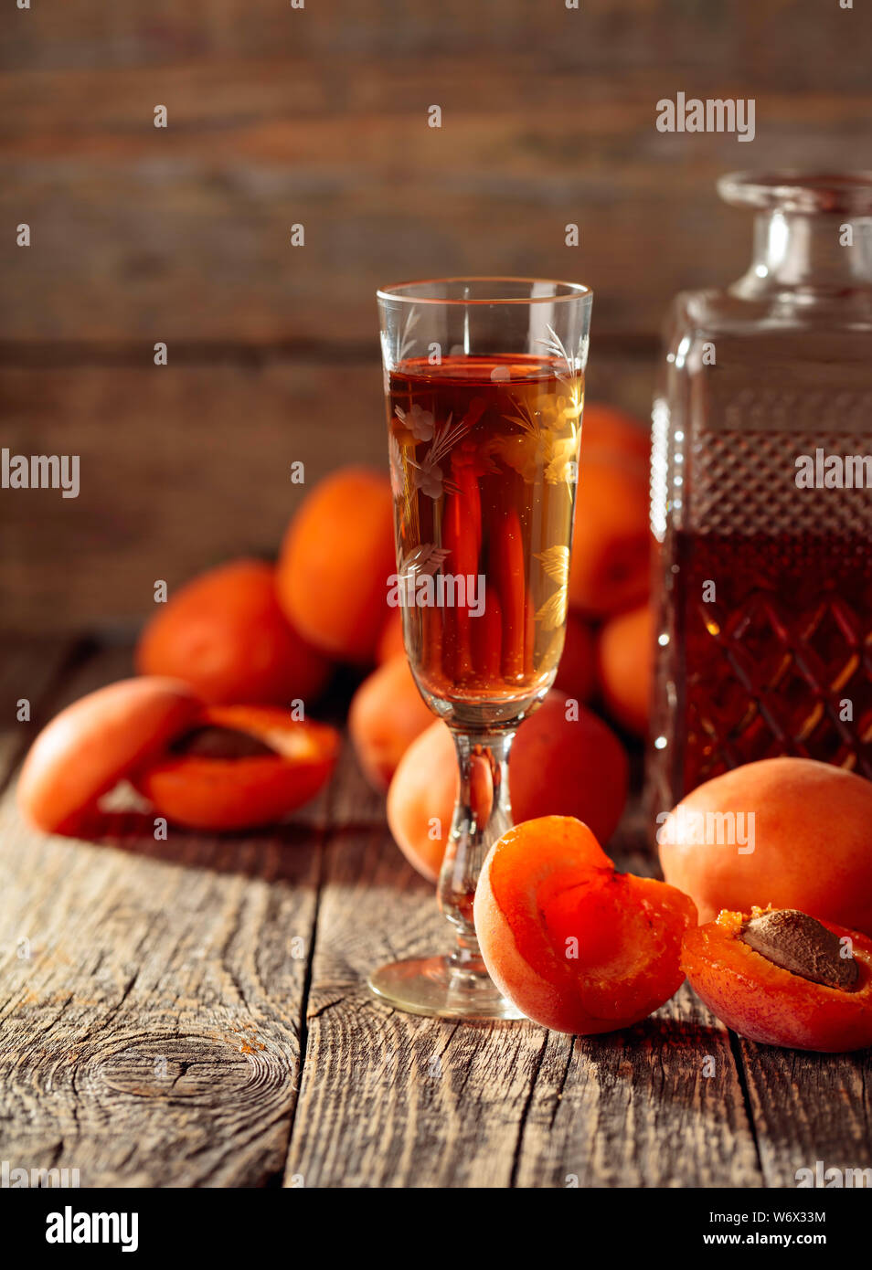 Apricot liquor and fresh apricots on a old wooden table. Wine and juicy ...