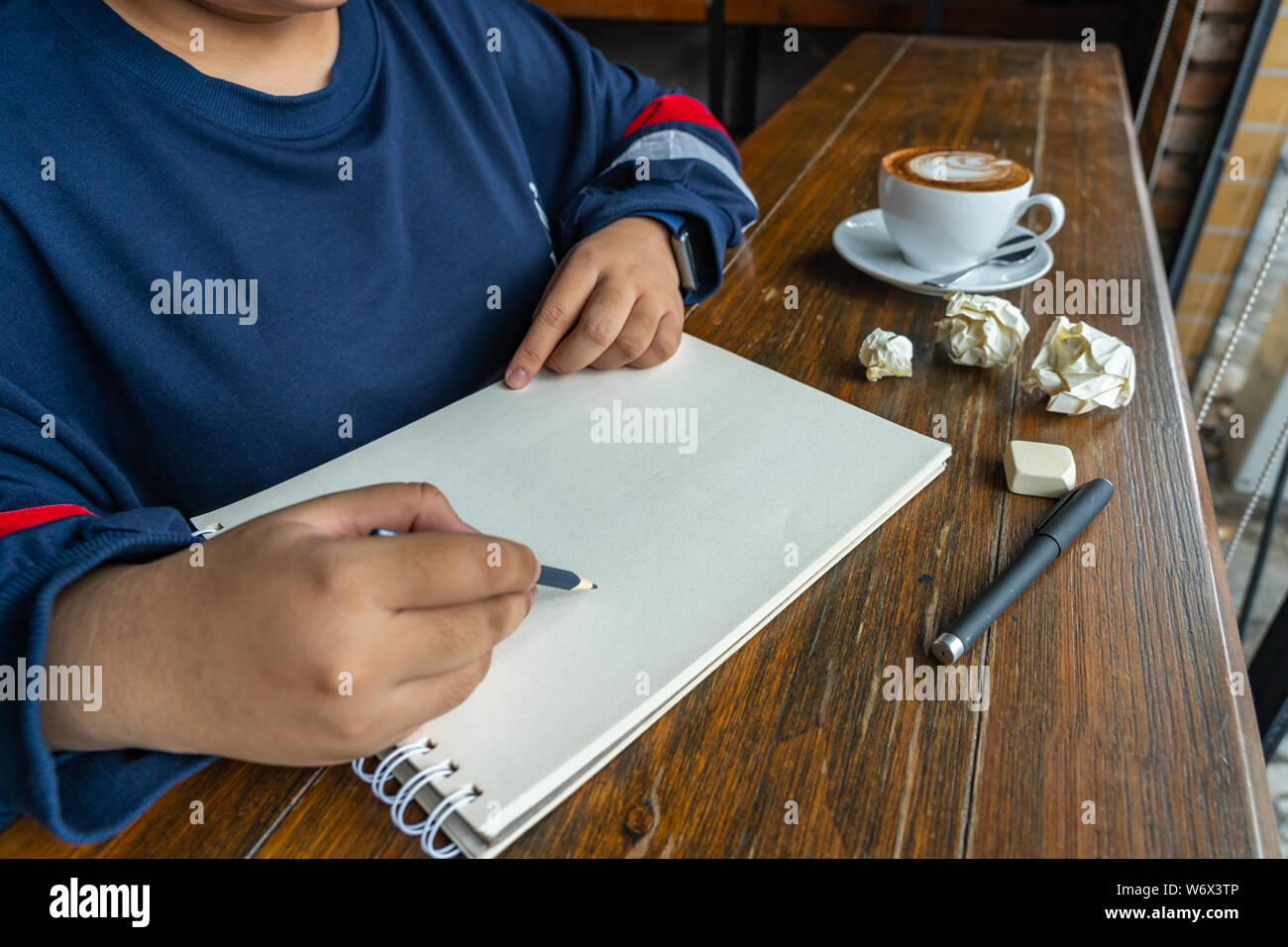 Student drawing on blank sketchbook next to crumpled paper balls Stock ...