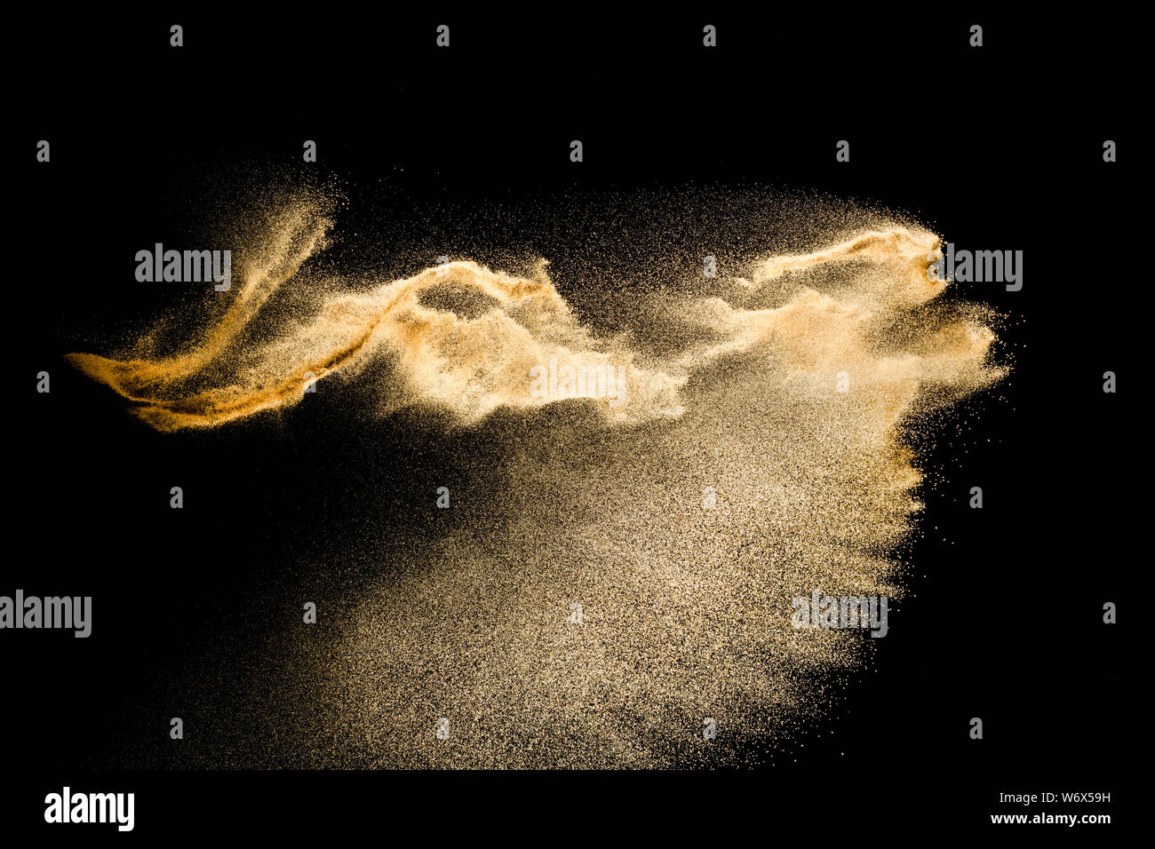Abstract sand cloud.Golden colored sand splash agianst dark background ...