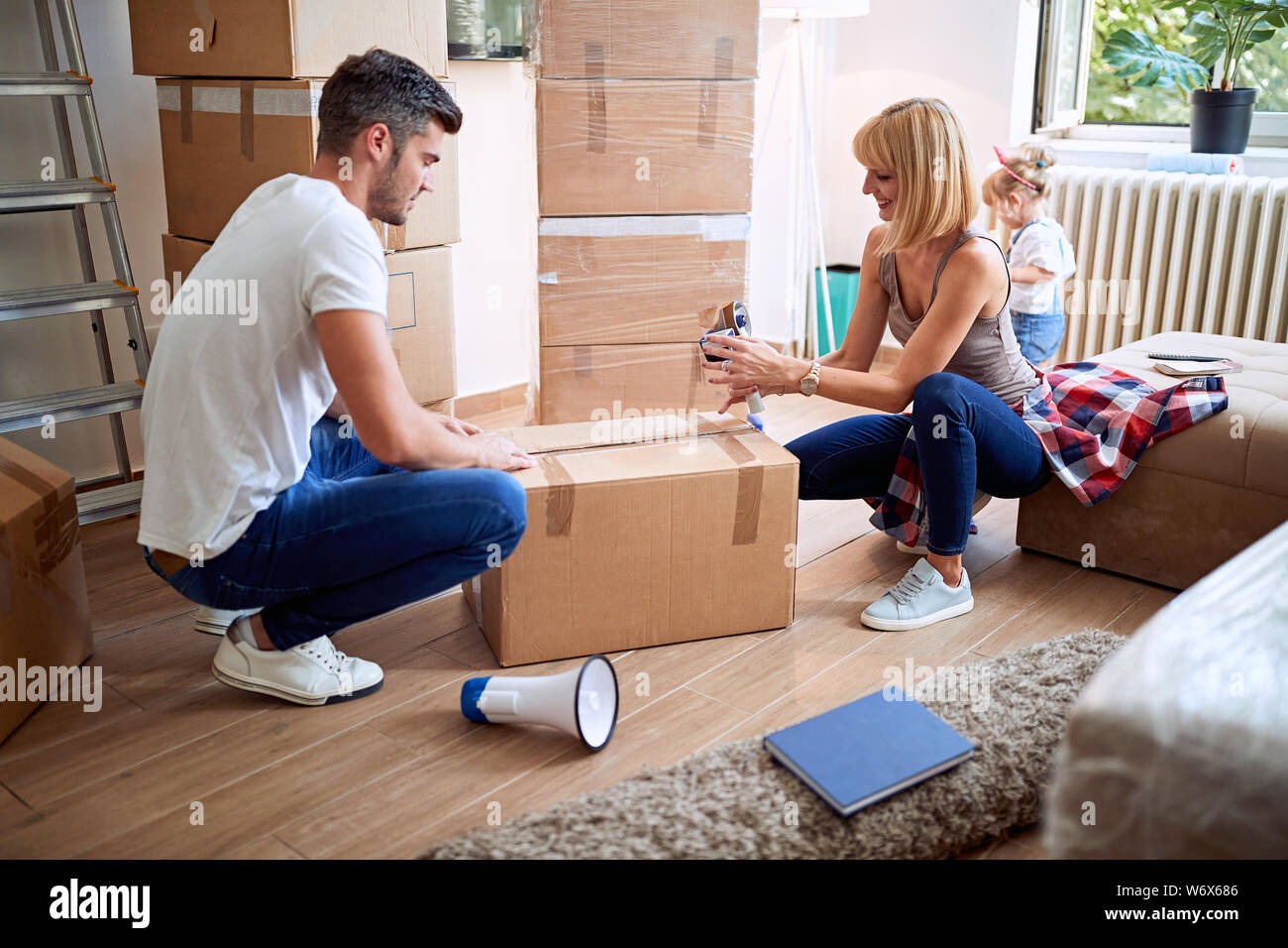 Happy young family unpack boxes moving to new home Stock Photo - Alamy