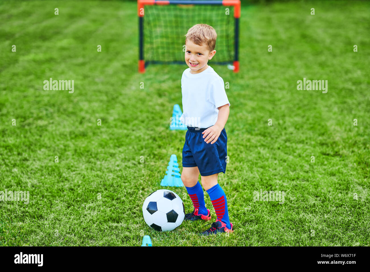 Little Boy practising football outdoors Stock Photo - Alamy
