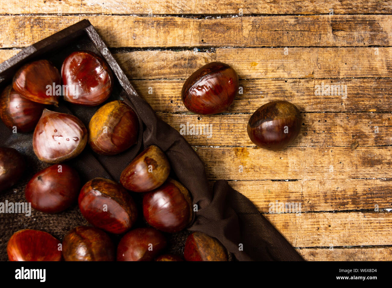 Fresh chestnuts on a rustic wooden table Stock Photo - Alamy