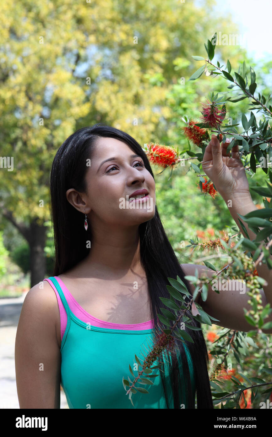 Young woman smelling flower on tree Stock Photo - Alamy