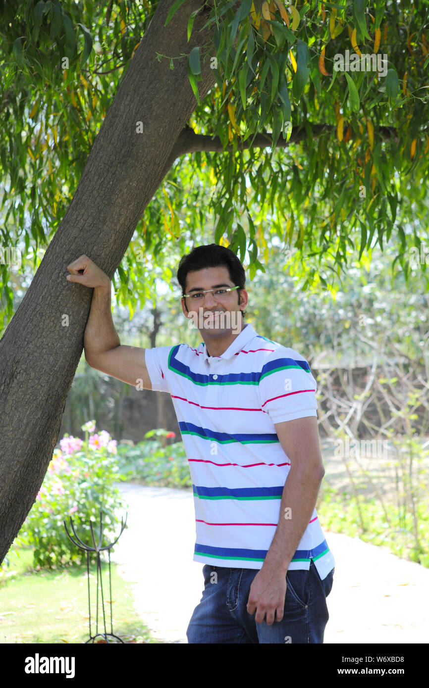Young man standing under the tree Stock Photo - Alamy