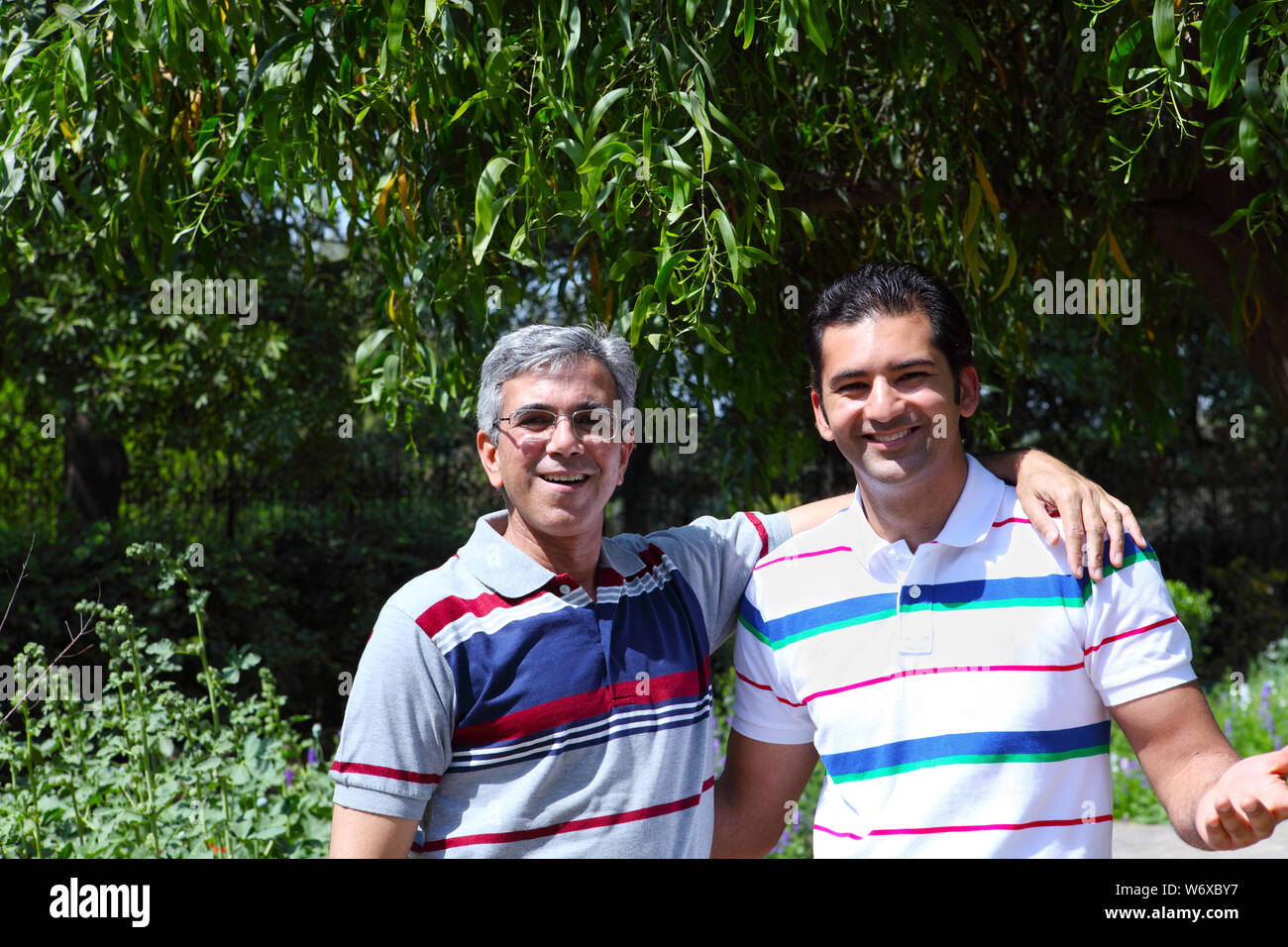 Young man smiling with his father Stock Photo - Alamy