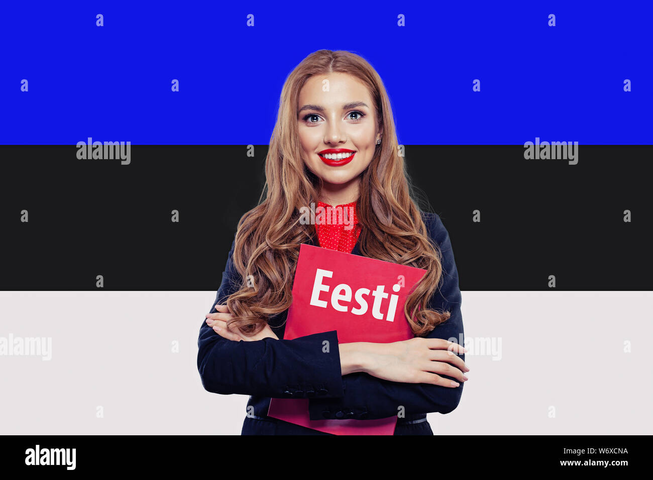 Portrait of beautiful woman student with book against the Estonia flag ...