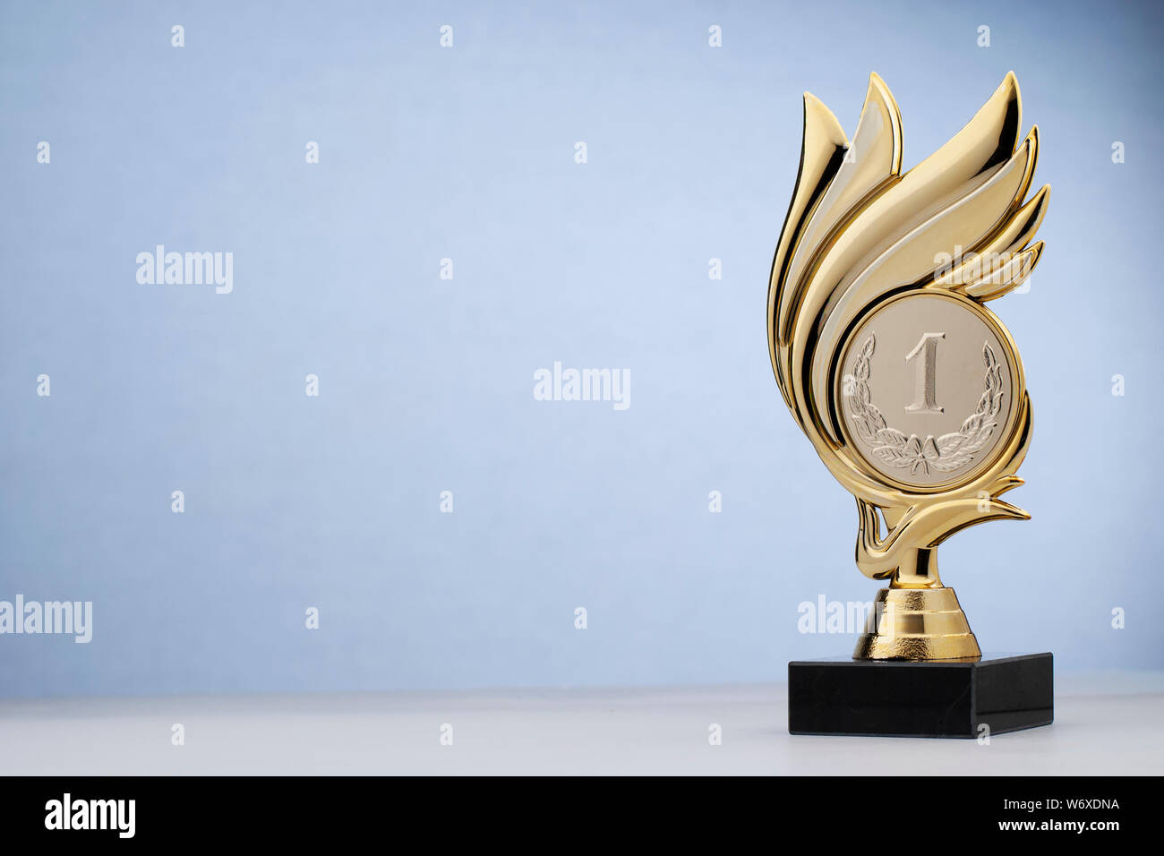 Shiny golden trophy in wreath shape with black pedestal for rewarding ...