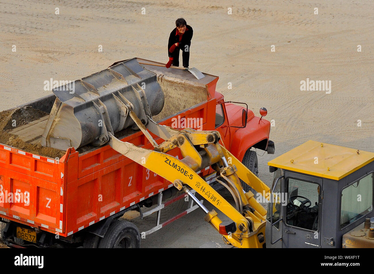 A female truck driver supervises the loading of her truck in Nantong ...