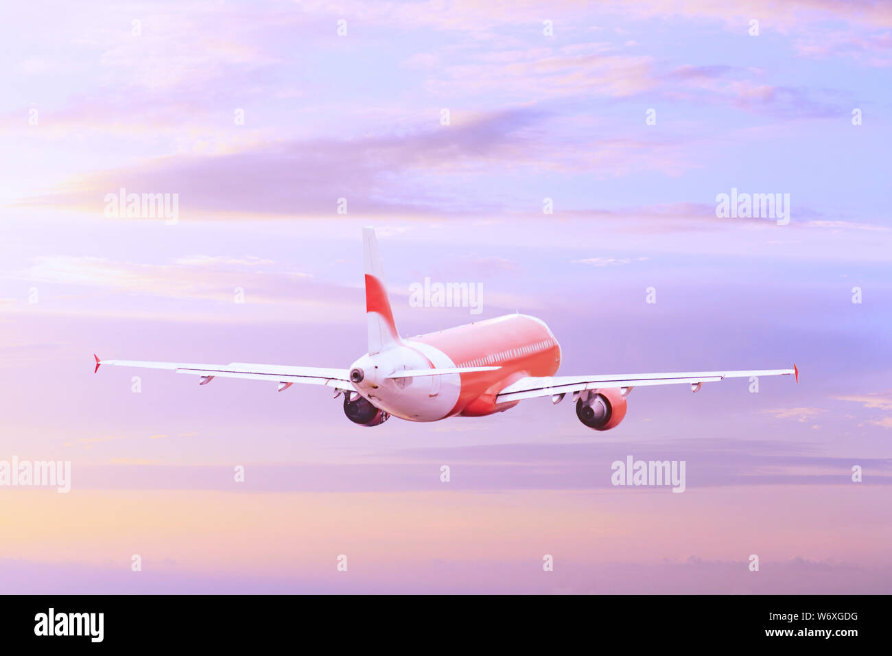 Plane flying in the faded purple sky at sunset. Aircraft air logistic ...