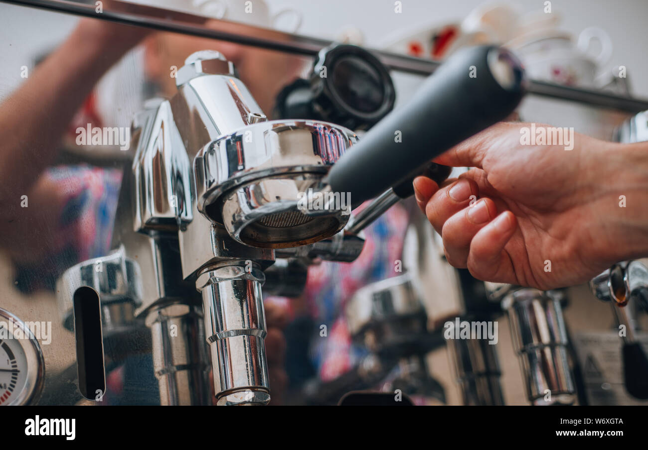 Preparing a cup of strong freshly brewed espresso coffee using a coffee ...