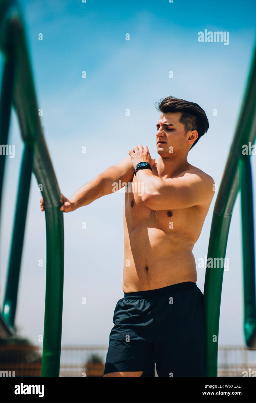 Portrait of a confident strong shirtless male bodybuilder preapiring ...