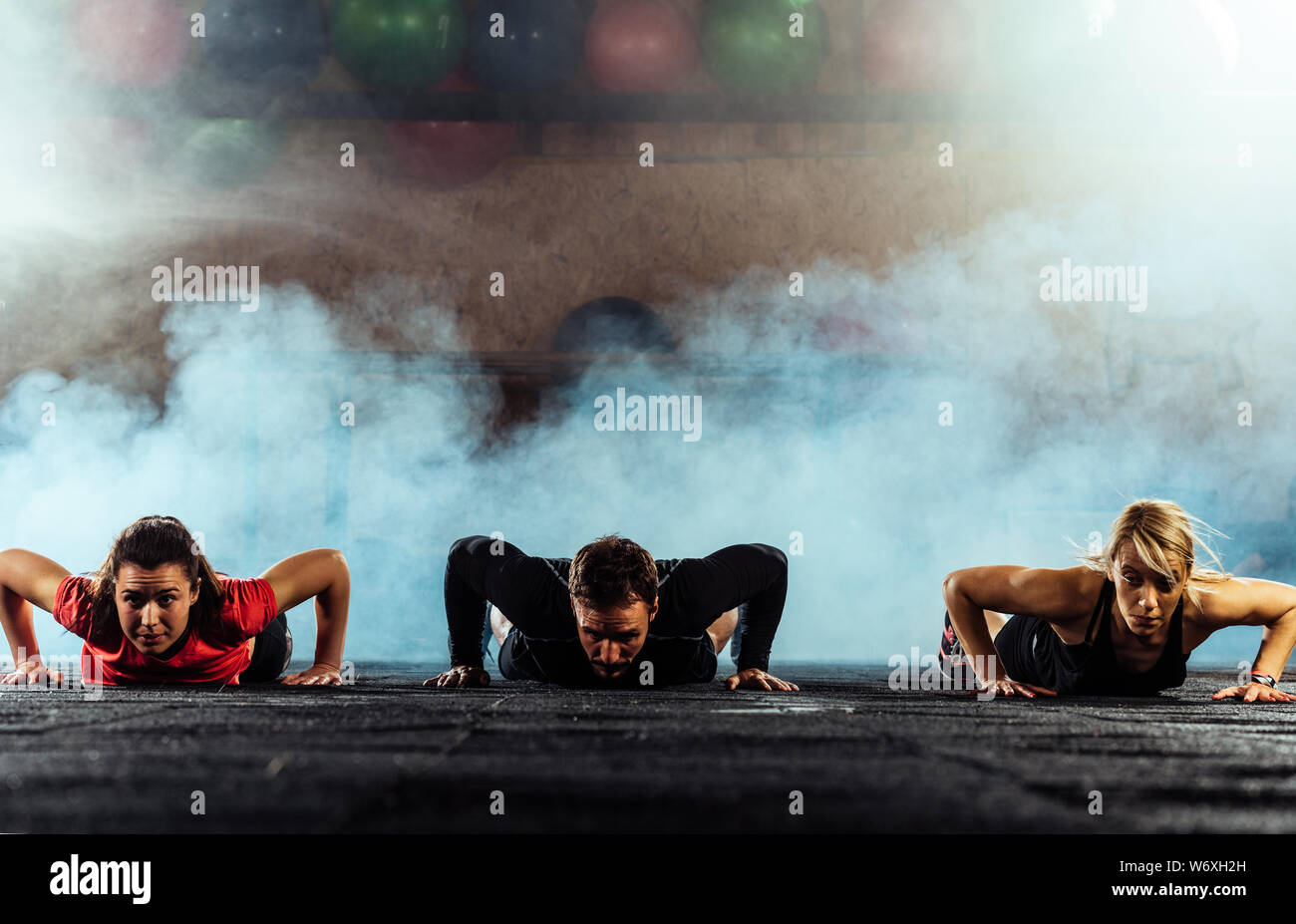 Team of sportive people doing pushups in crossfit gym Stock Photo - Alamy