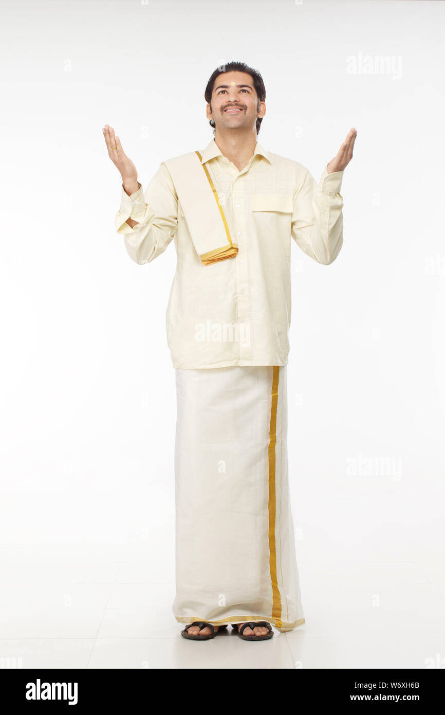 South Indian man standing with his arm outstretched Stock Photo - Alamy