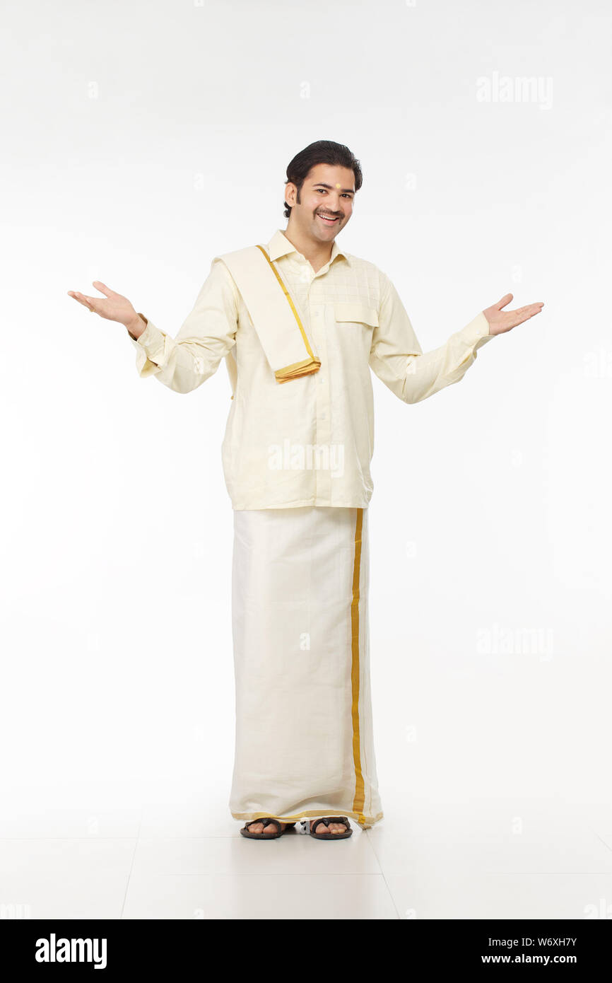 South Indian man smiling with his arm outstretched Stock Photo - Alamy