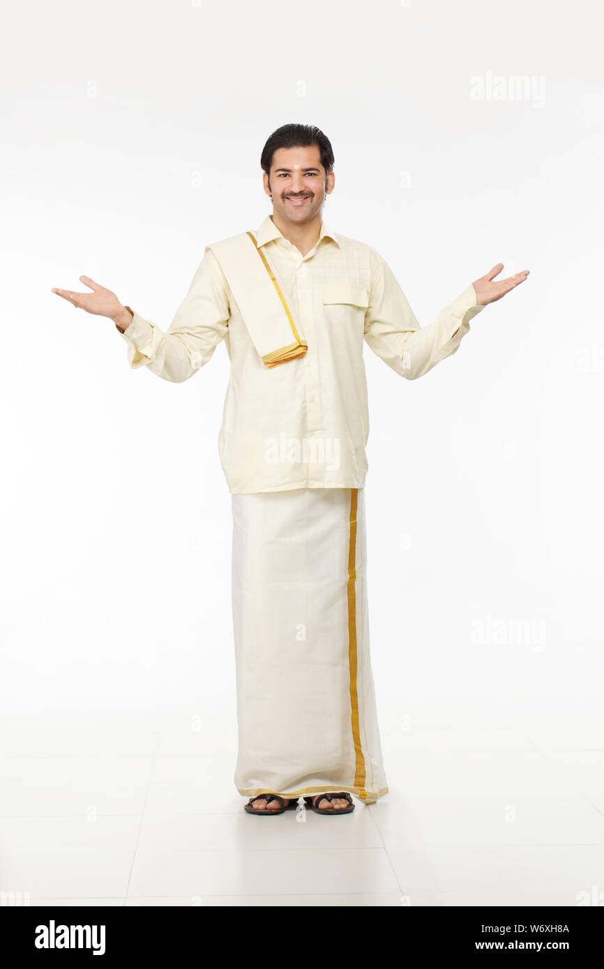 South Indian man smiling with his arm outstretched Stock Photo - Alamy