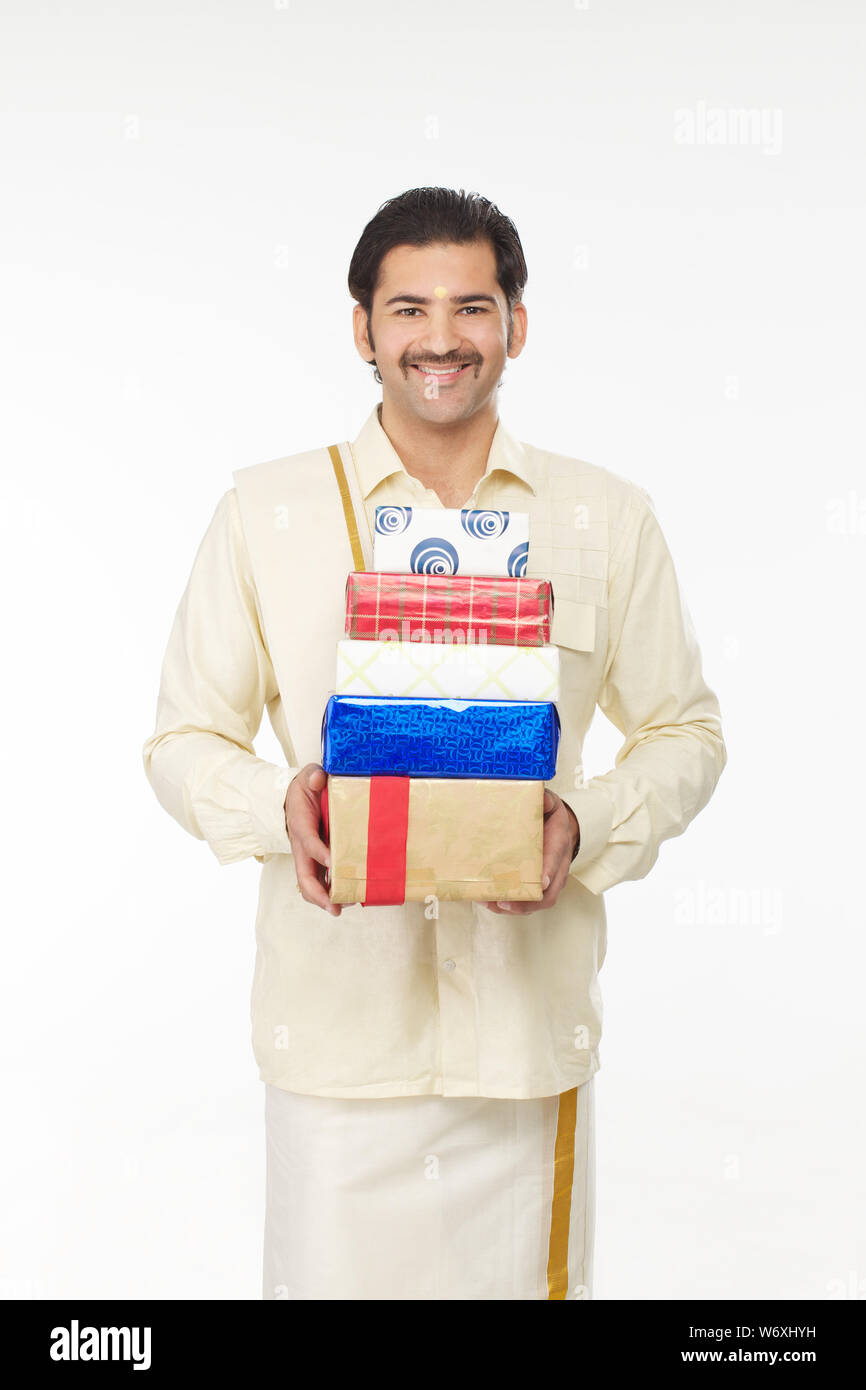 South Indian man holding gift boxes and smiling Stock Photo - Alamy