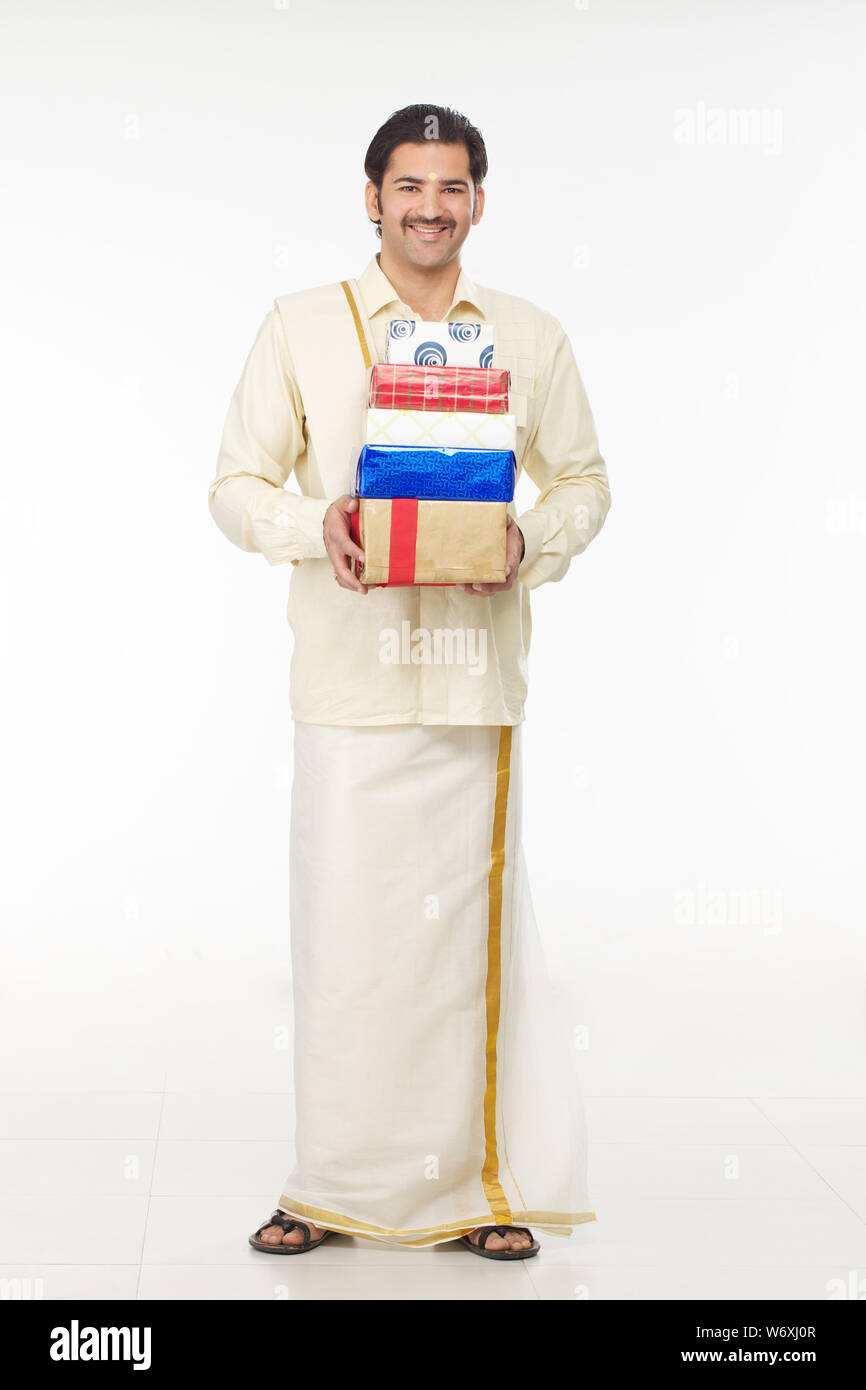 South Indian man holding gift boxes and smiling Stock Photo - Alamy