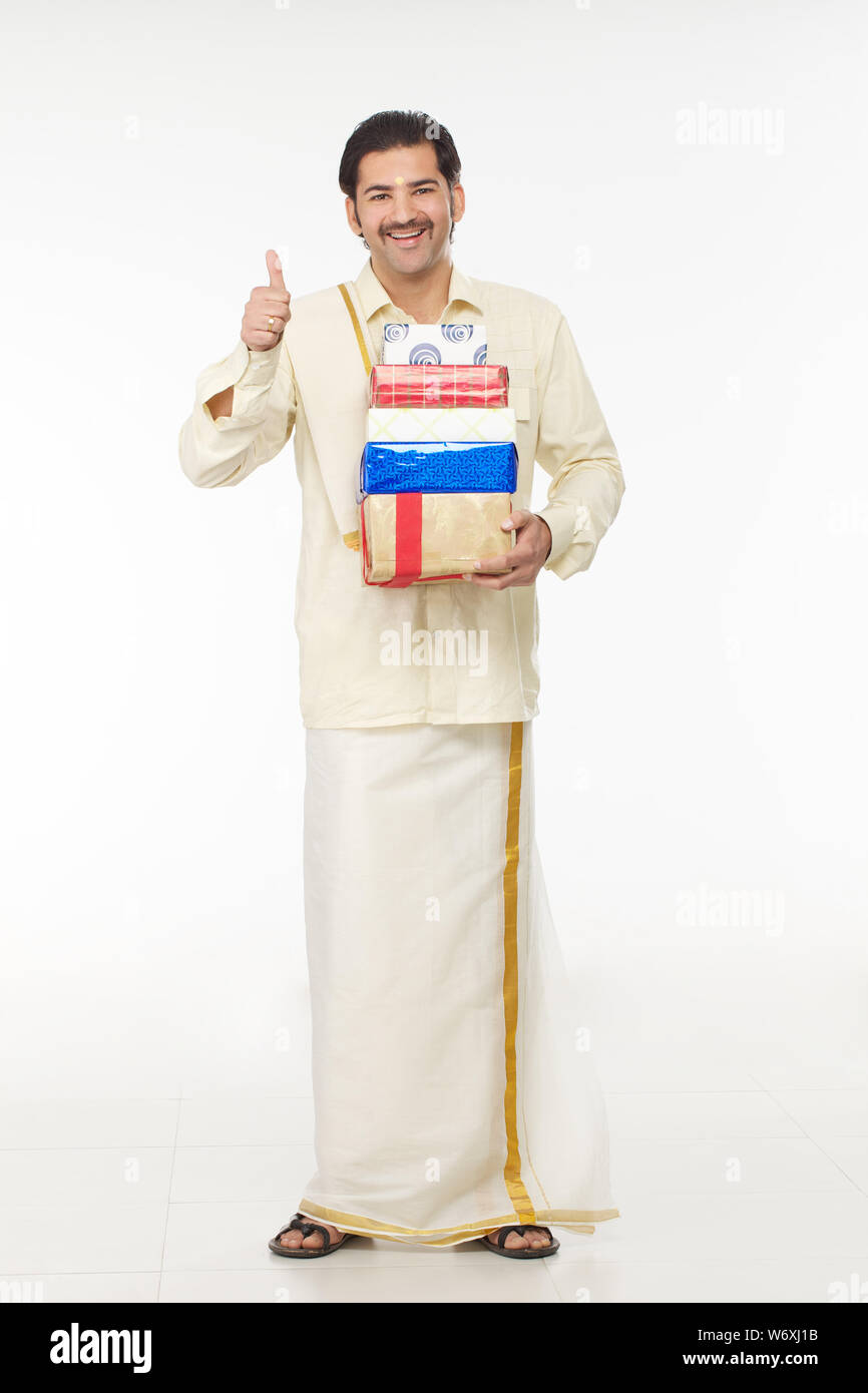 South Indian man holding gift boxes and smiling Stock Photo - Alamy