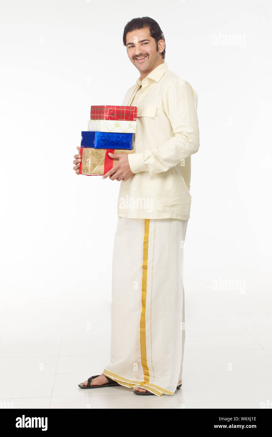 South Indian man holding gift boxes and smiling Stock Photo - Alamy