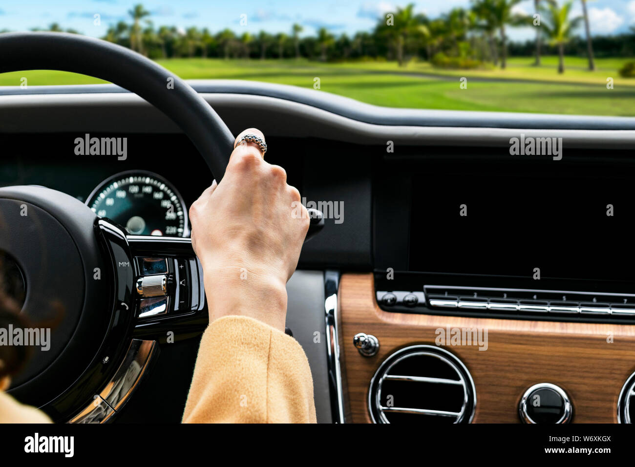 Woman's hands on the steering wheel driving modern luxury car. Concept ...