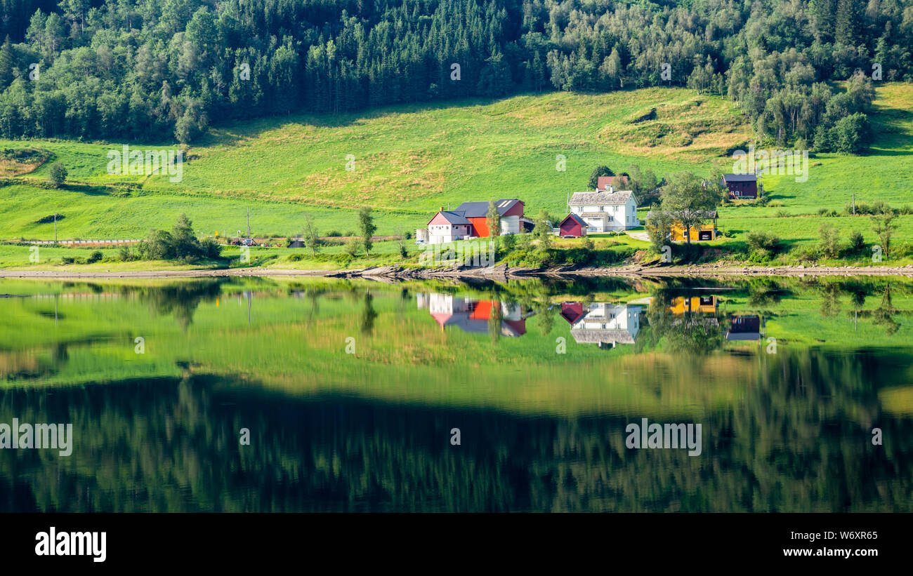 Traditional Norwegian summer farm along lake Vangsvatnet reflected in ...