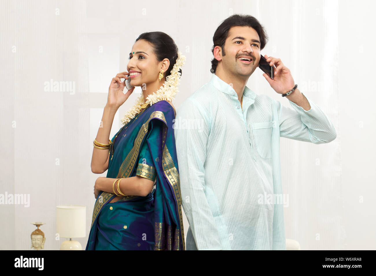 South Indian couple talking on mobile phones and smiling Stock Photo ...