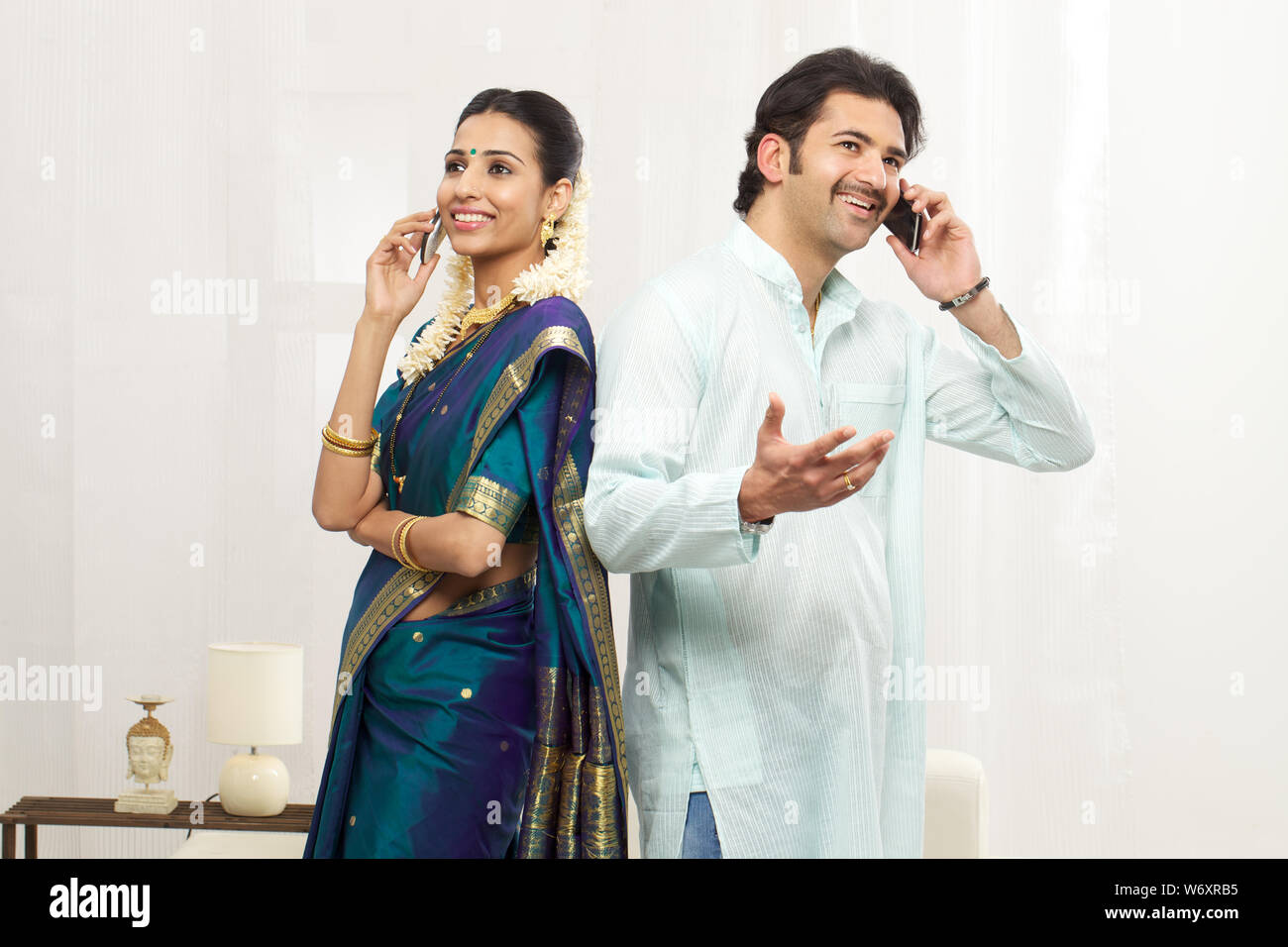 South Indian couple talking on mobile phones and smiling Stock Photo ...